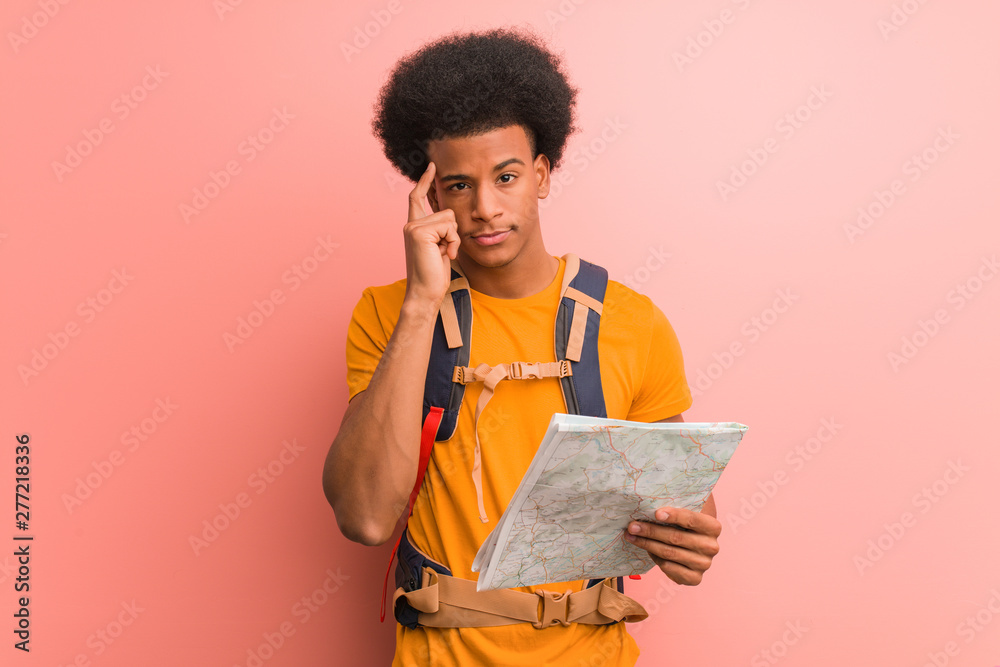 Young african american explorer man holding a map thinking about an ...