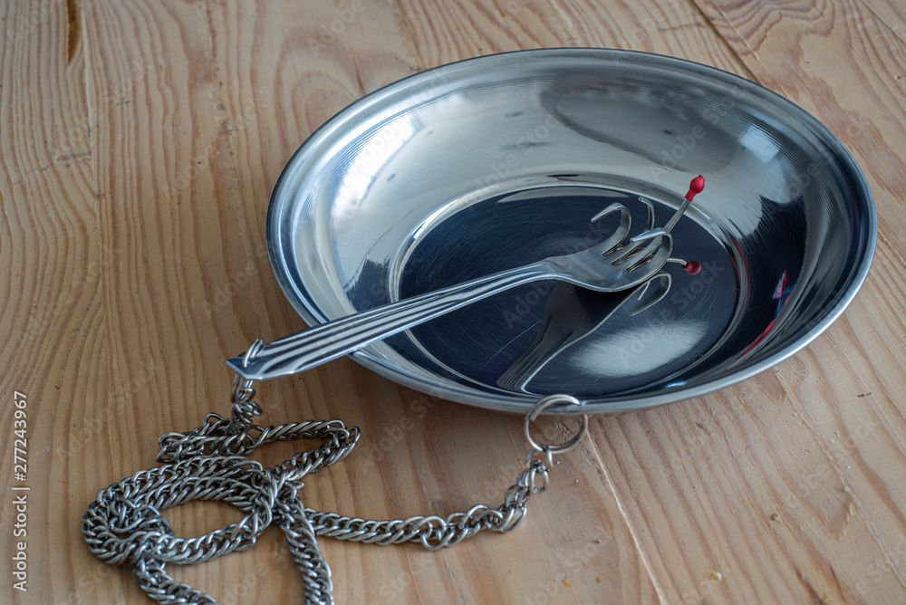Fork as deformed as a human hand when chained to a metal plate Stock ...
