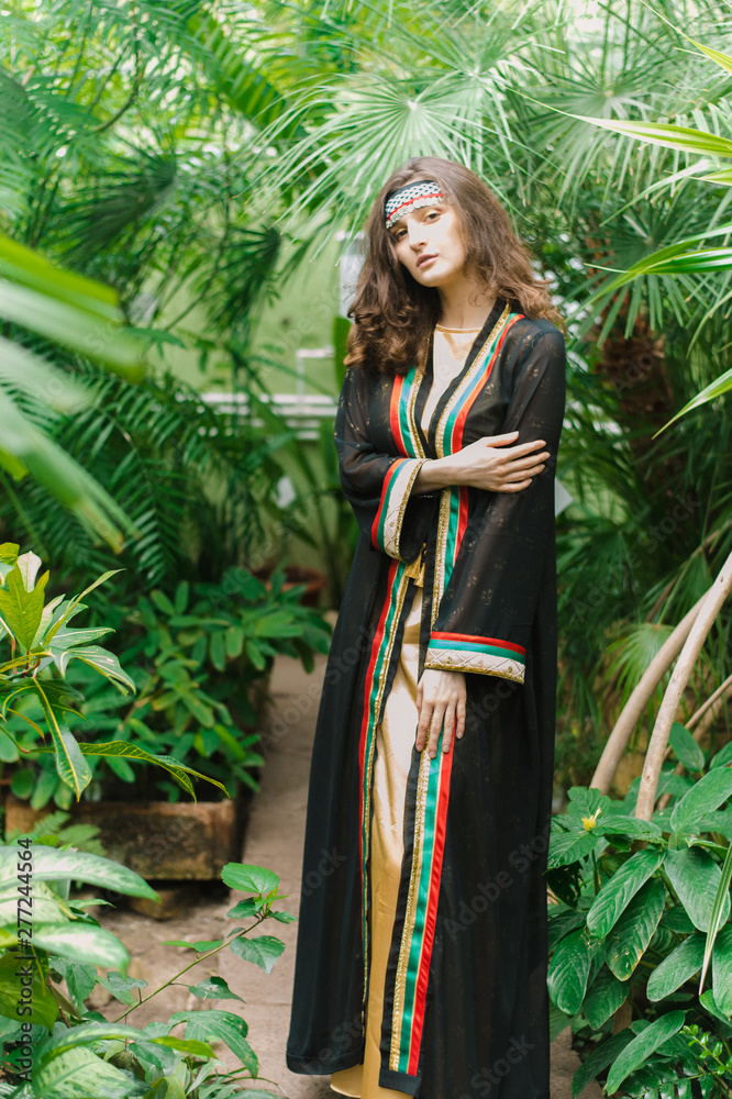 The girl from Jordan on the background of plants and palm leaves ...
