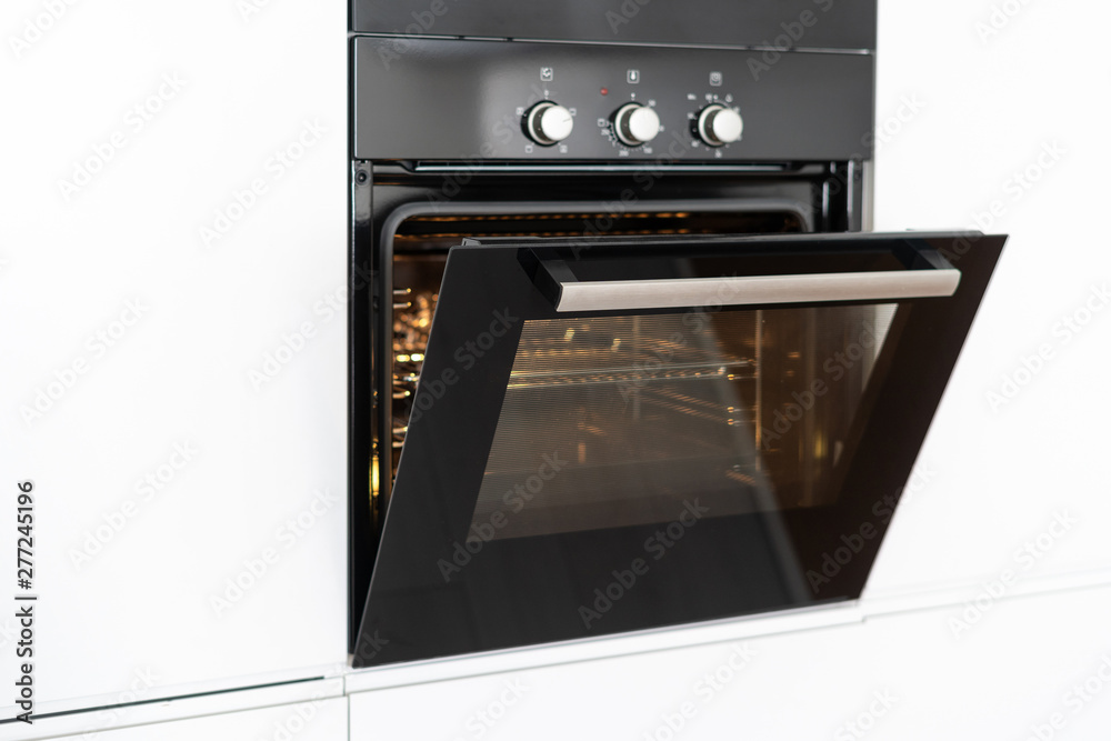 Modern built in oven with open glass door on white kitchen Stock Photo ...