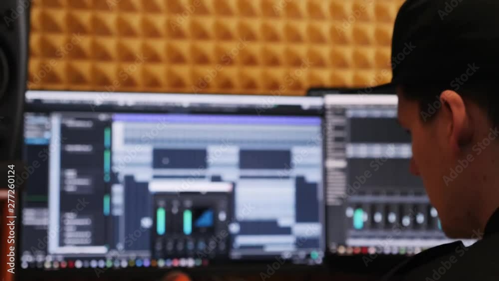 Sound engineer at home recording studio is looking at screen with ...