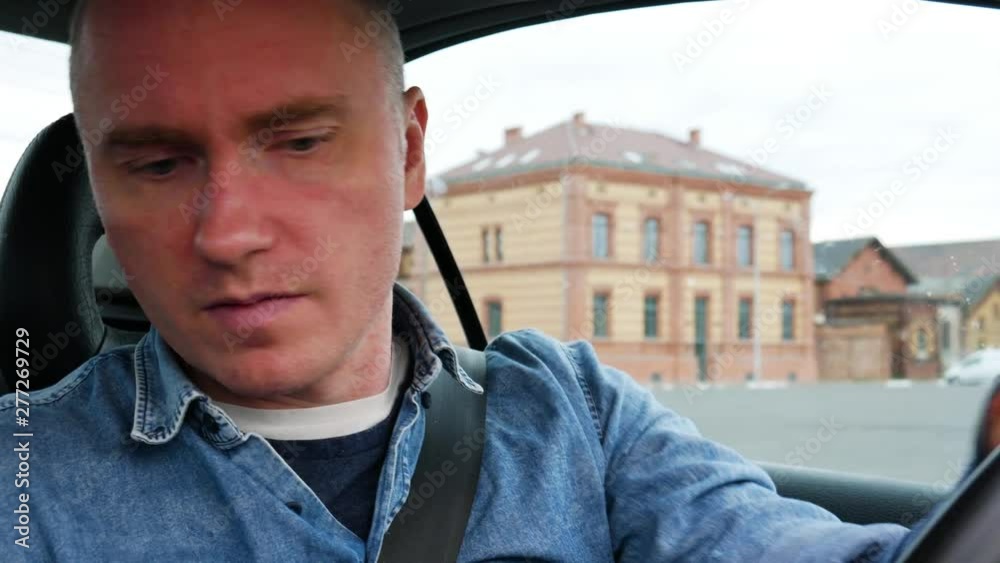 A young man driver moves in reverse. Close-up portrait in the car Stock ...