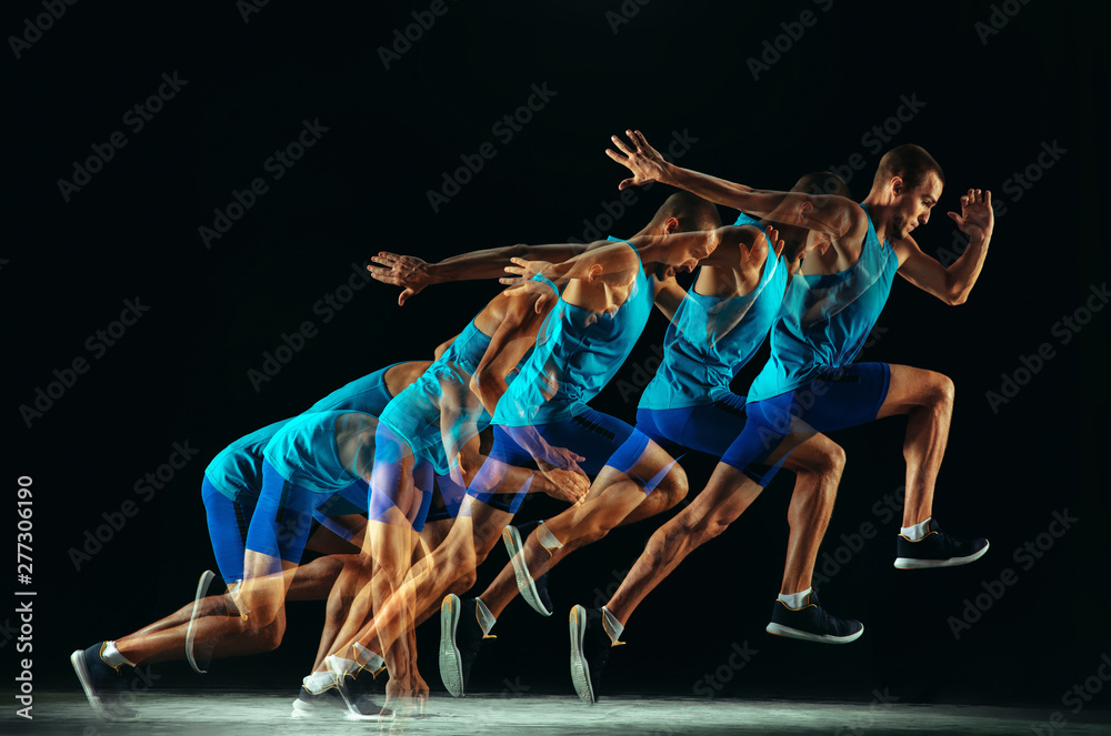Professional male runner training isolated on black studio background ...