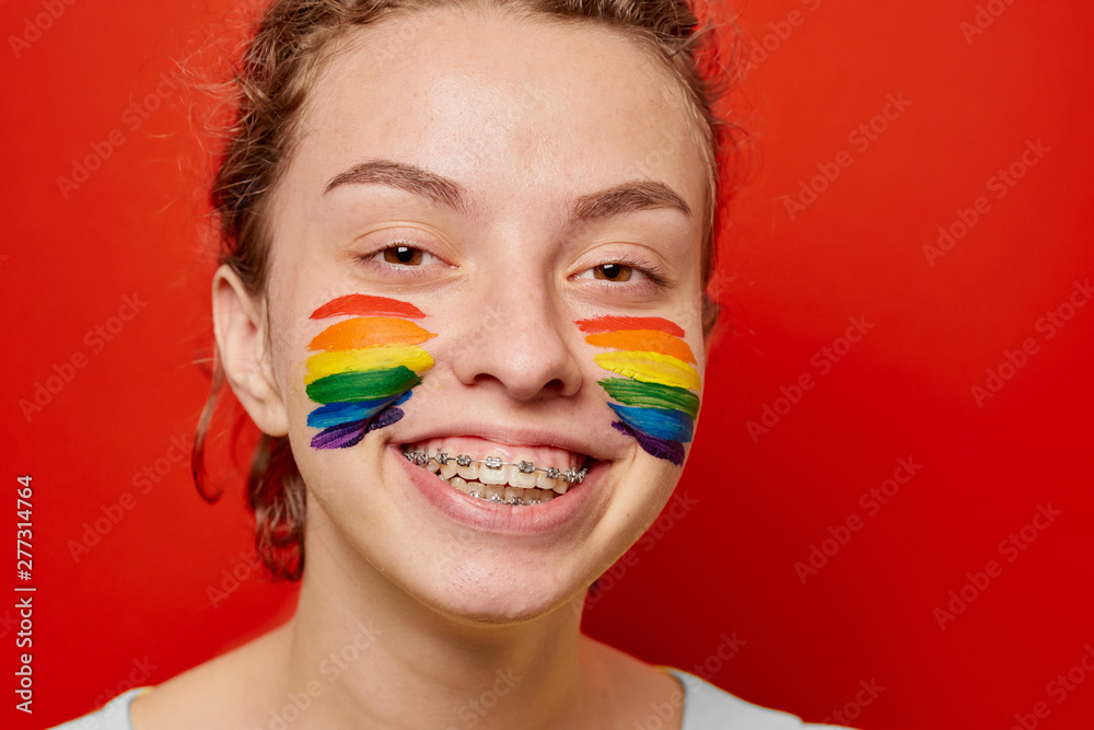 Girl with pride flag painted on her cheeks smiling Stock Photo | Adobe ...