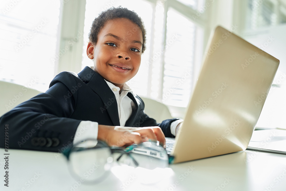 African child as a manager at the laptop Stock Photo | Adobe Stock