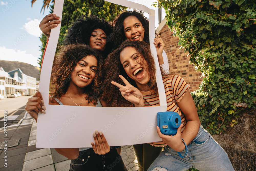 Excited friends with blank photo frame Stock Photo | Adobe Stock