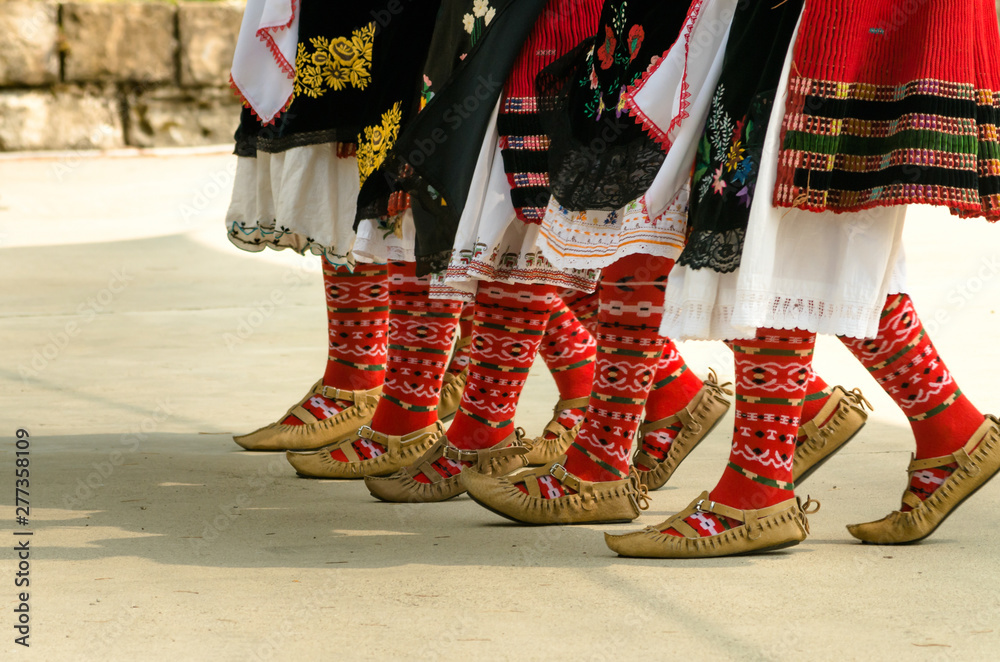 Girls dancing folk dance. People in traditional costumes dance ...