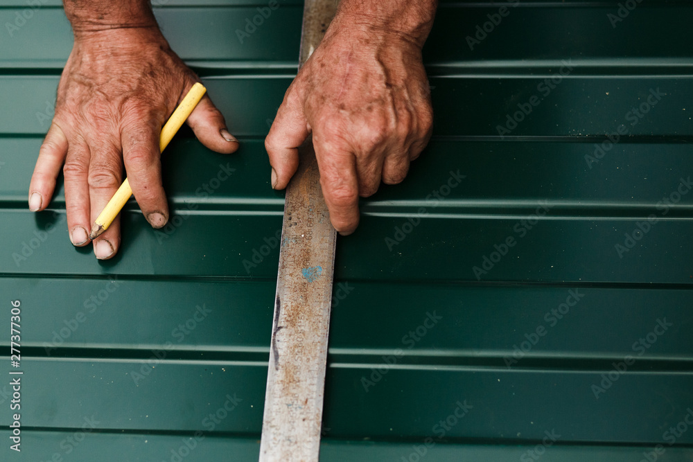 the master draws on metal with a simple pencil on a ruler, the master ...