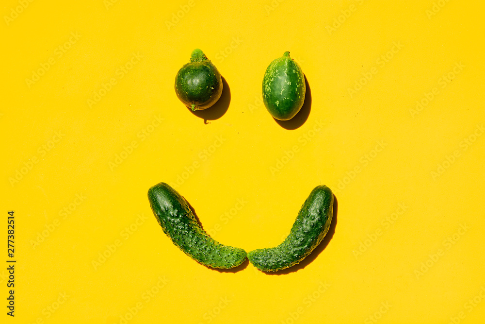 Different sizes and forms cucumbers on a yellow background forms a ...