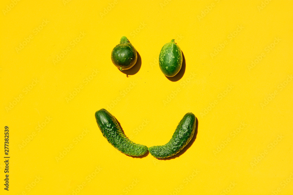 Different sizes and forms cucumbers on a yellow background forms a ...