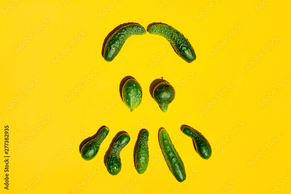Different sizes and forms cucumbers on a yellow background forms a ...