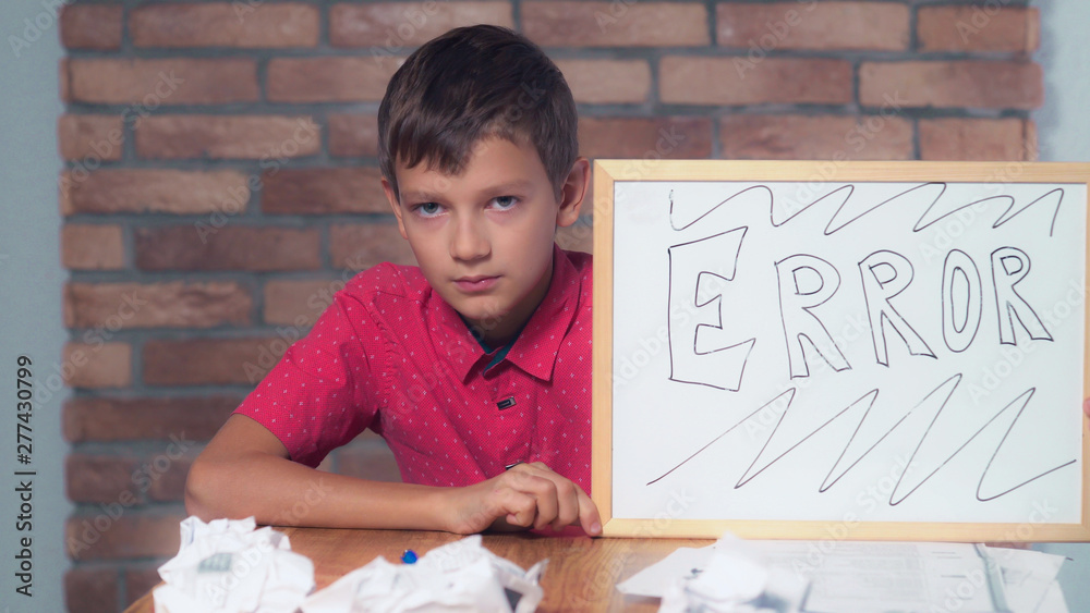 Portrait little boy showing whiteboard with handwriting error. Child ...