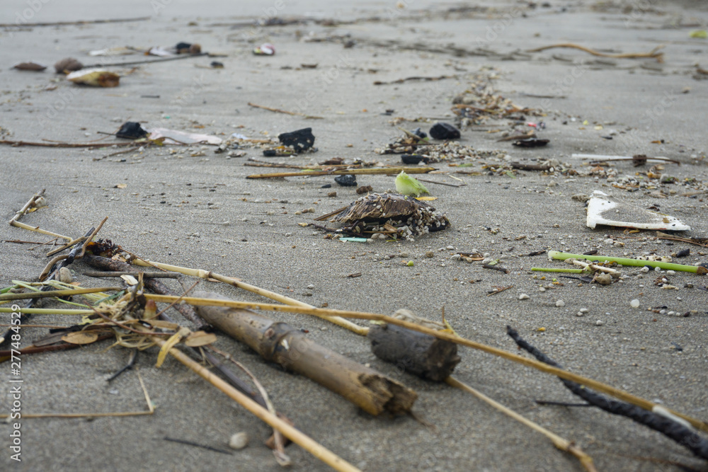Spilled garbage on the beach of a big city. Empty used dirty plastic ...