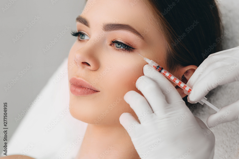 woman with beautiful eyes getting beauty injections. Biorevitalization ...