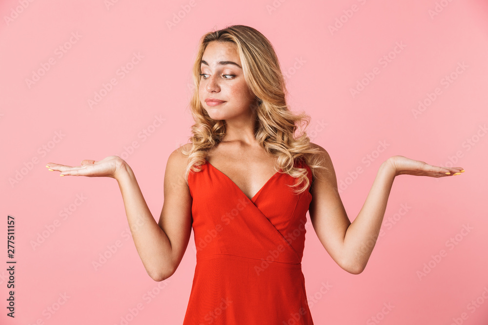 Confused young pretty blonde cute woman in dress posing isolated over ...