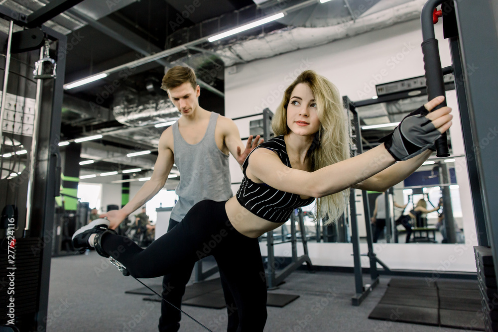 Sporty girl doing stratching legs exercises with assistance of her ...