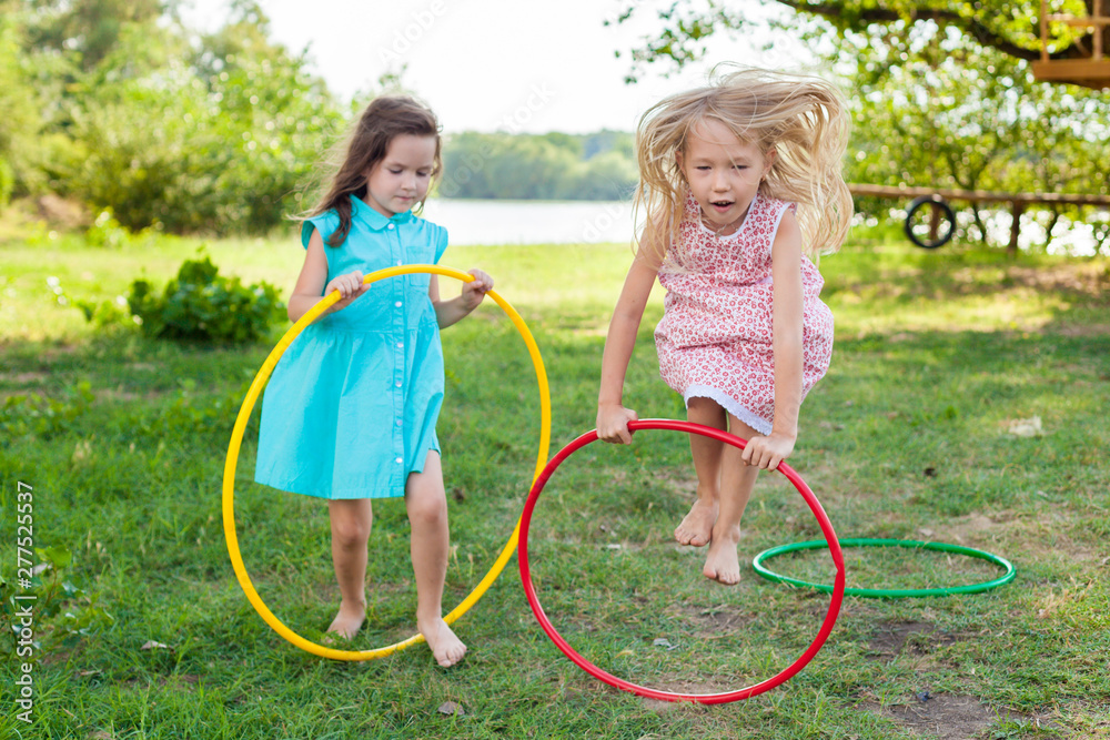 children play with hula Hoop and train their skills in summer. Cheerful ...