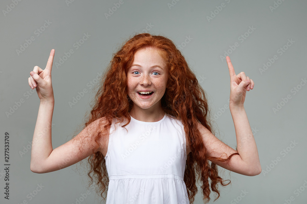 Nice happy little girl with ginger hair and freckles, smiles and looks ...