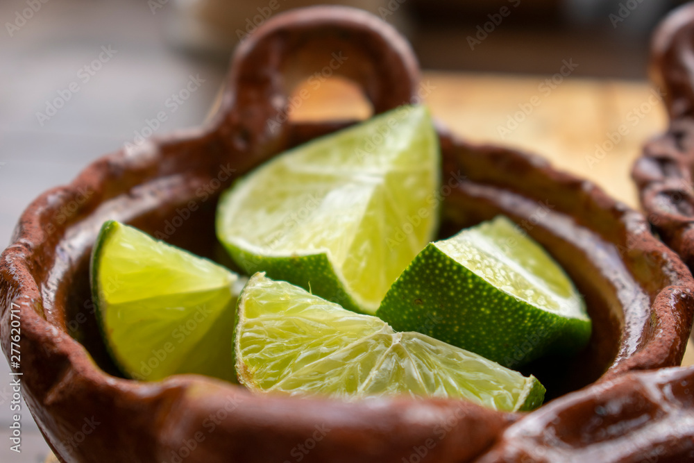 Limones partidos en cazuela de barro sobre mesa para acompañar una ...