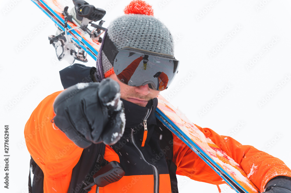 Professional skier athlete in an orange black suit with a black ski ...