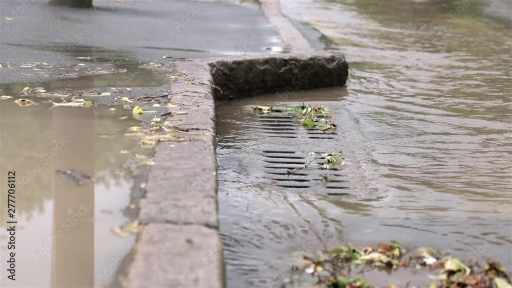 Video „Rain flowing into a storm water sewer system. Storm sewer after ...