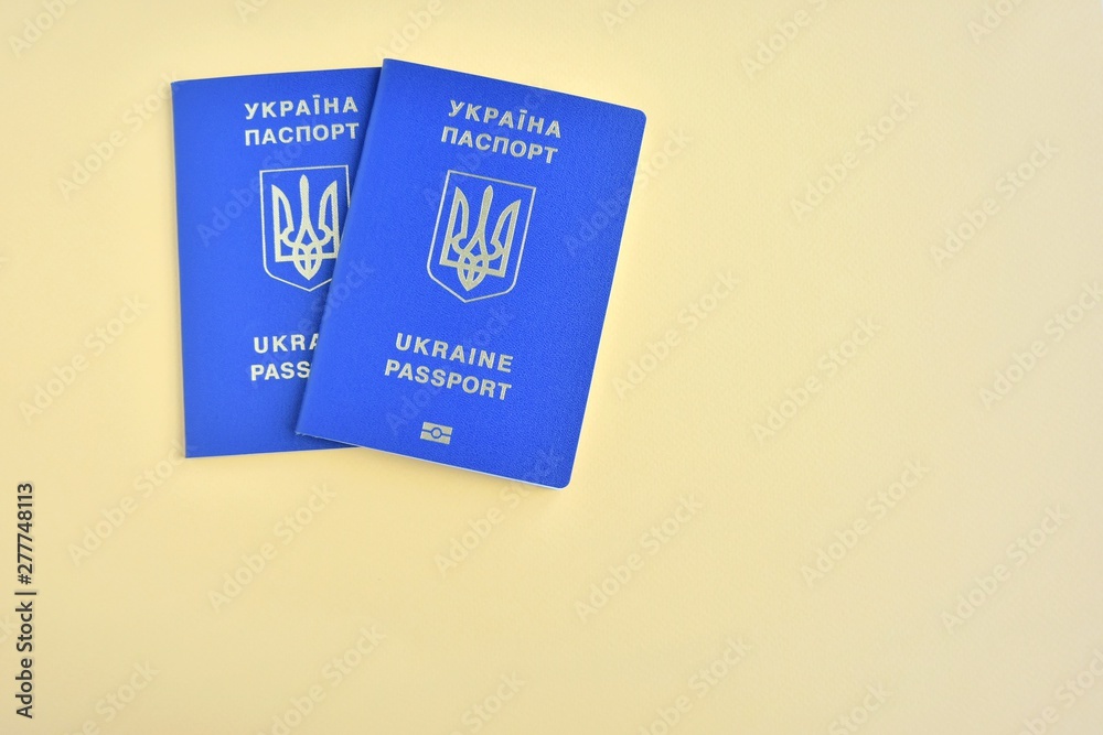 Two Ukrainian id passport with a golden symbol trident on yellow ...