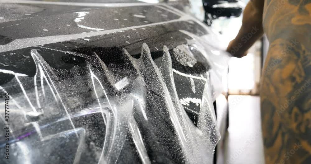 Close up to PPF installation process on a front headlight and hood. PPF ...