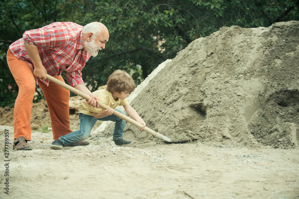 Child and works. Little son worker with shovel. Little son helping his ...