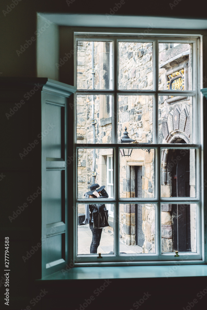 View through old window frame with aged stone building behind in soft ...
