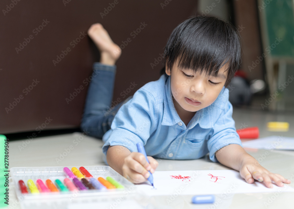 asian little boy is writing homework on floor at home.Asian child using ...