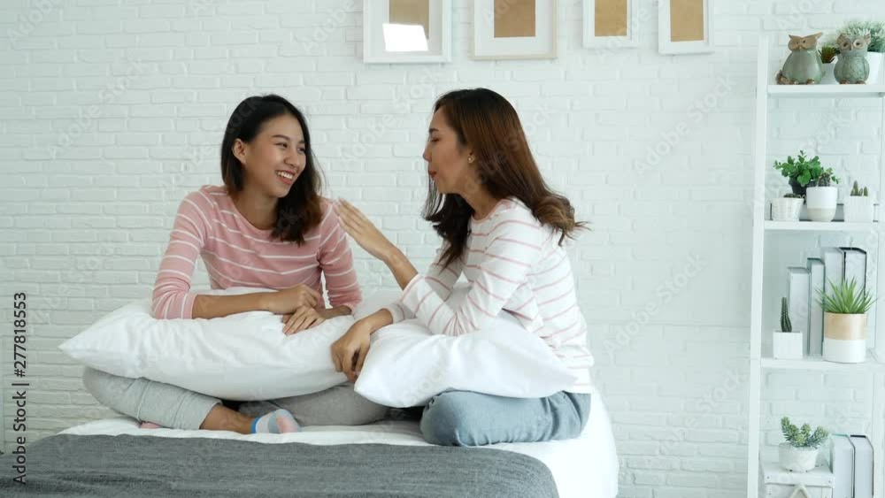 Two young women talk laughing together happy friendship chatting in ...