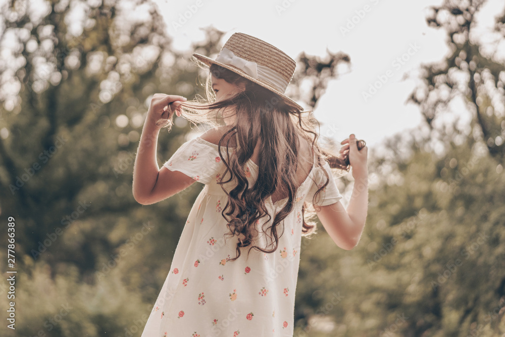Back view portrait of young happiness pretty girl in garden on sunset ...