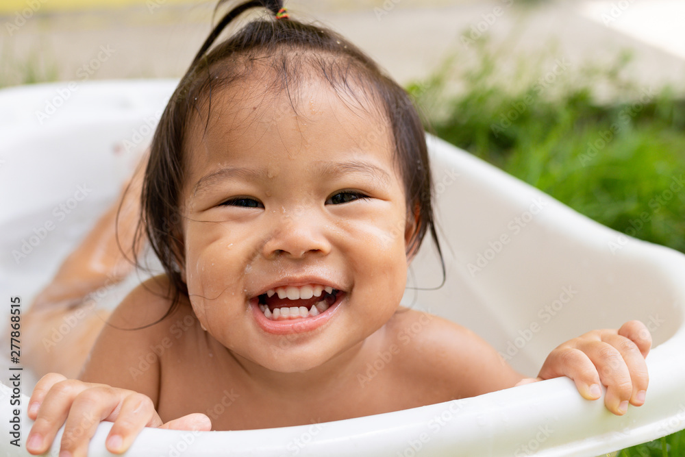 Cute little girls baby taking bath outdoors. Stock Photo | Adobe Stock