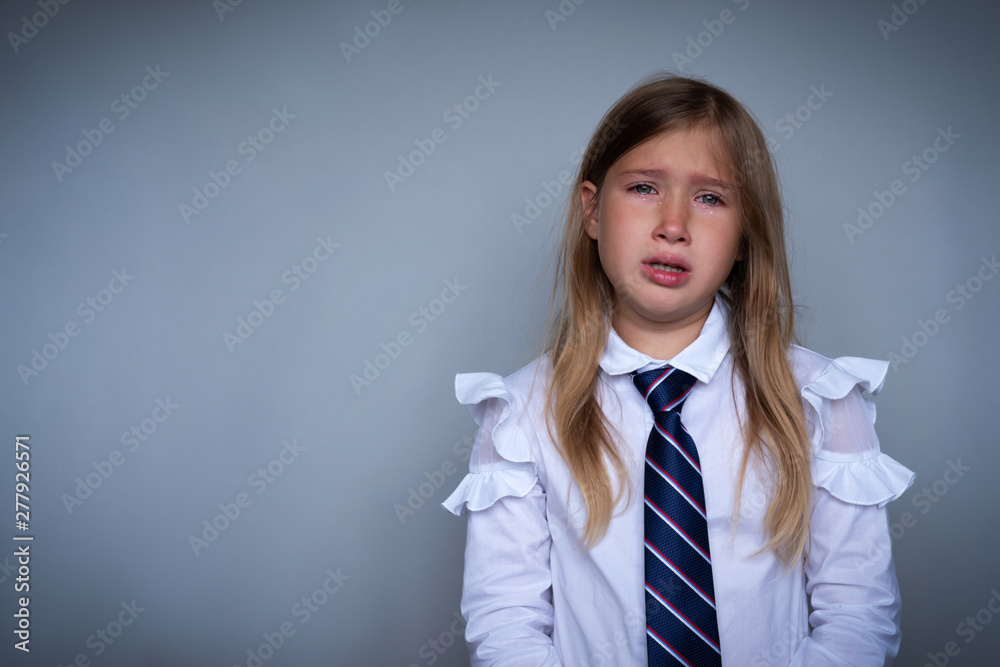 Small schoolgirl covering face, crying portrait. Preteen stressed ...