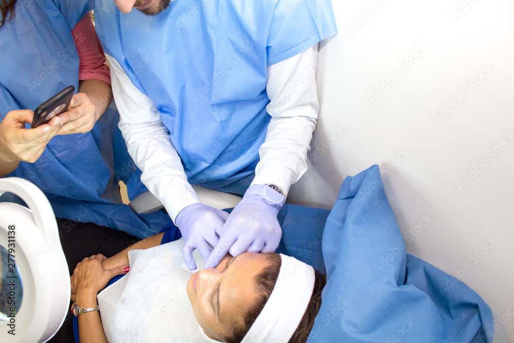 In a doctor's office a doctor explains an aesthetic treatment on a ...