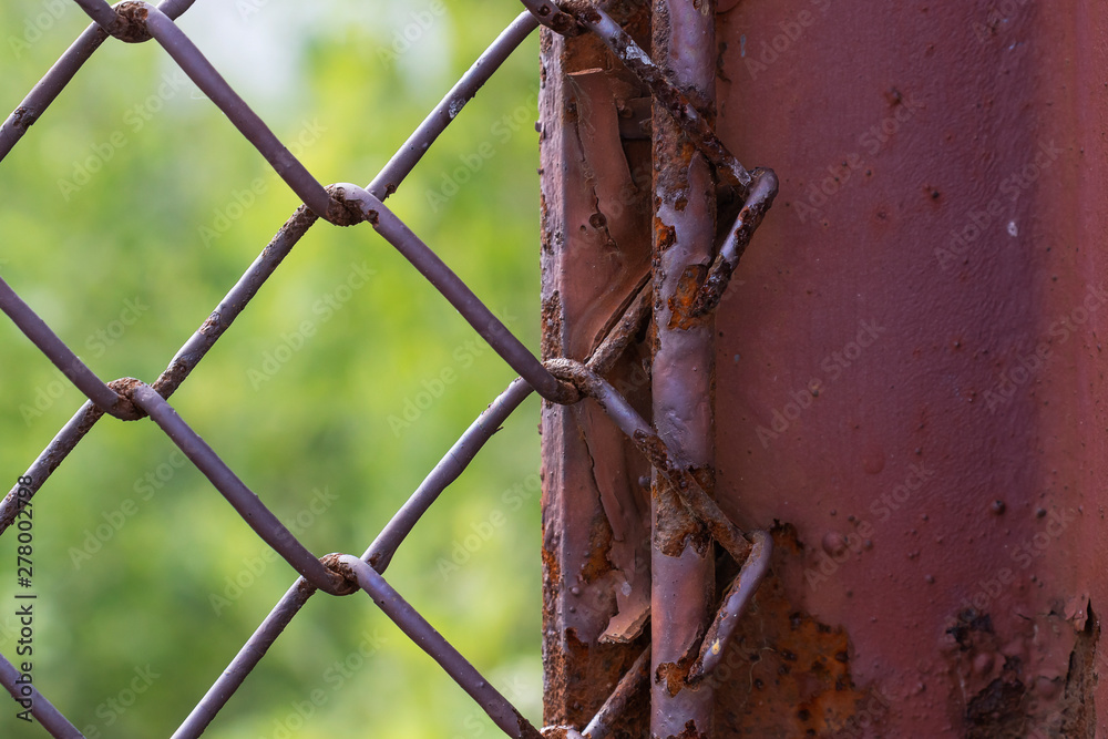 Rows of wire mesh and rusty metal pillar of fence. Wire mesh grid ...