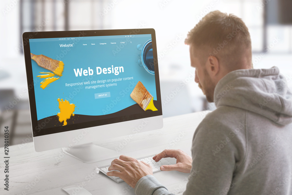 Guy work on modern web site on computer in graphic, web design studio ...
