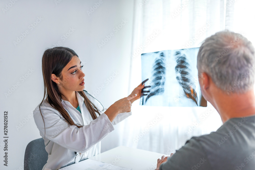 Female doctor explaining checkup result to her patient using x-ray ...