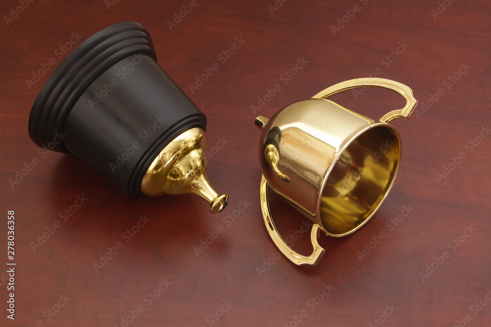 Broken golden champion trophy cup on wooden background, loose and ...