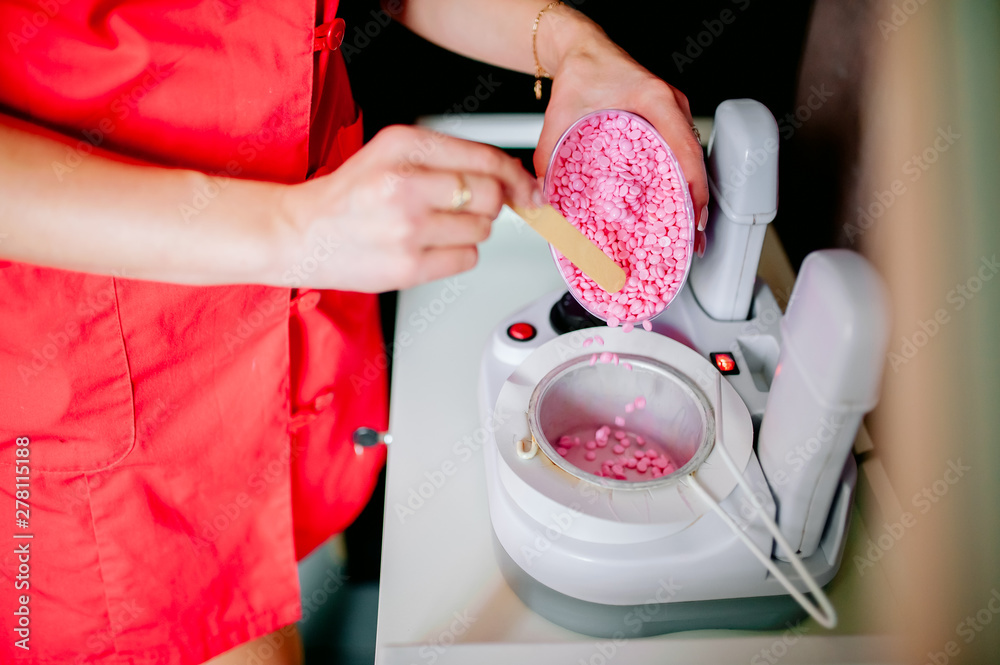 Preparation of pink wax for shugaring. Close-up wax for depilation is ...