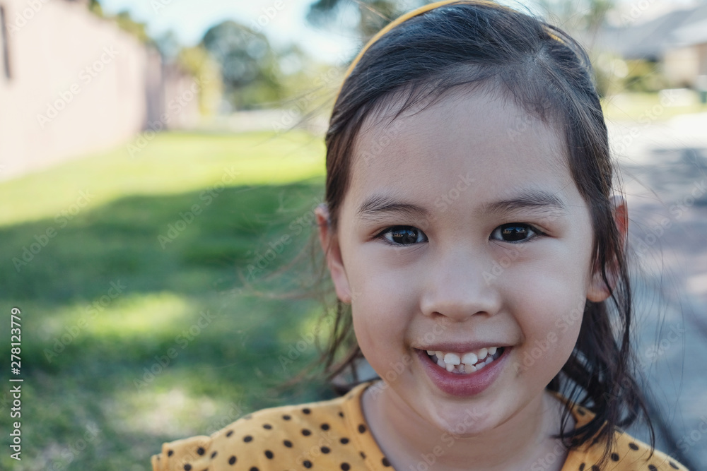 Cute happy and healthy mixed Asian little girl wearing yellow polka dot ...