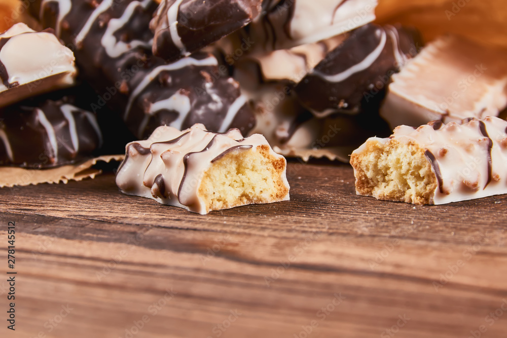 One broken cookie and long sticks shortbread cookies in dark and white ...