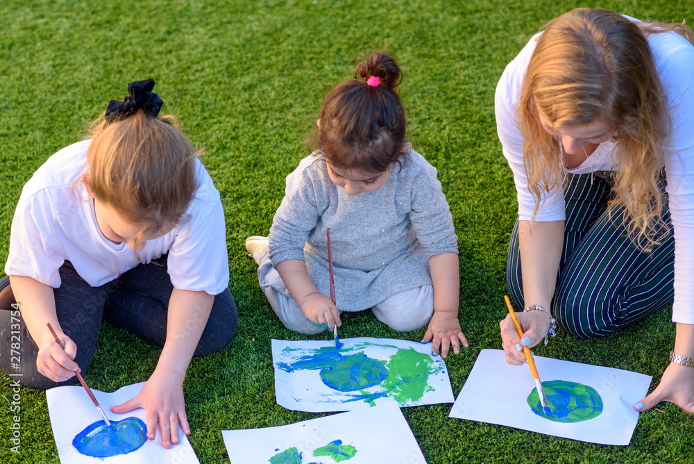 Beautiful little girl drawnig a picture of earth globe. Child painting ...