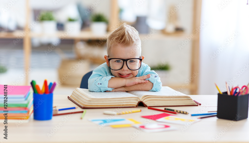 funny child boy doing homework writing and reading at home. Stock Photo ...