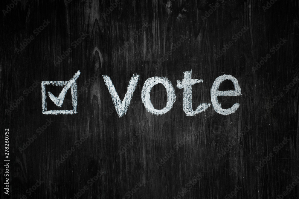 Political activism sign: handwritten word "vote" in black background ...