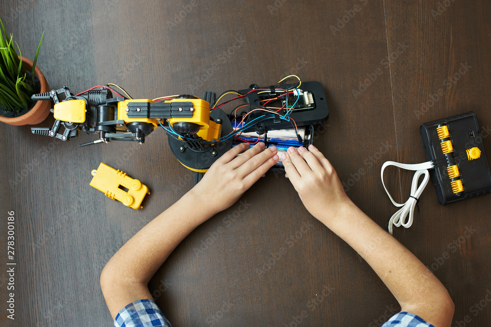 Young boy assembling a robotic arm kit Stock Photo | Adobe Stock