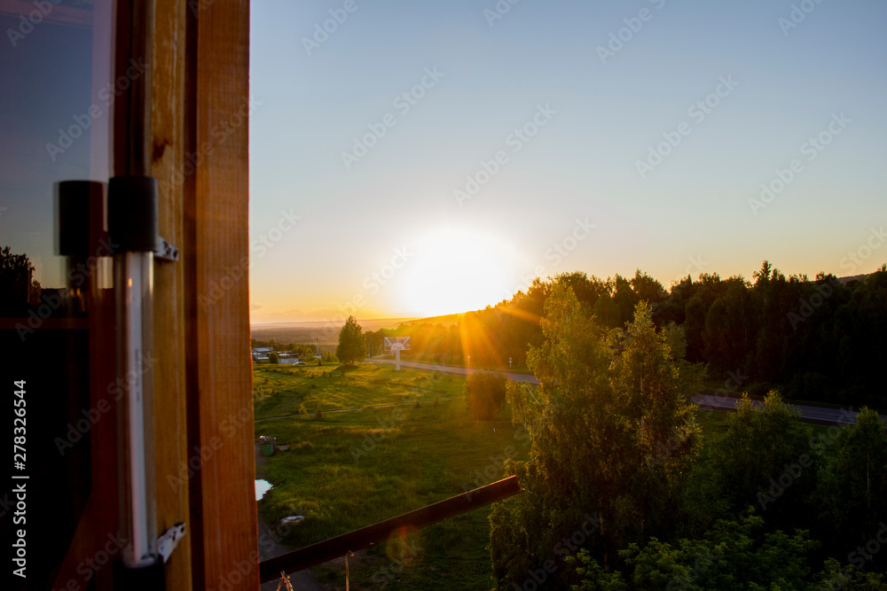 sunset from the window from the fifth floor. The sun illuminates the ...