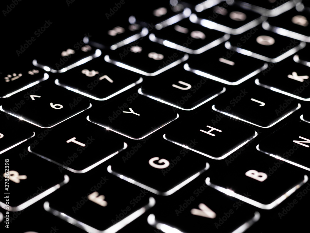 Black and white close-up on illuminated keys of computer keyboard ...