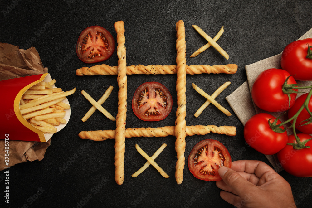 Game of tic tac toe of french fries and tomatoes. Choosing healthy vs ...