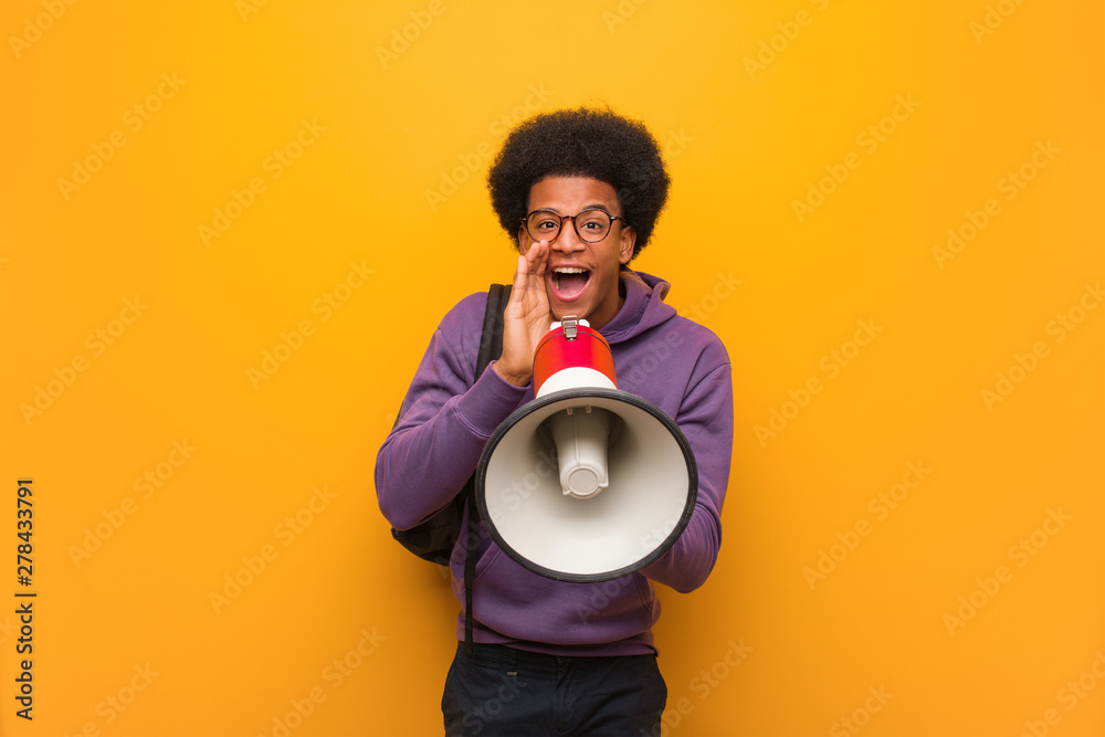 Young african american man holdinga a megaphone shouting something ...